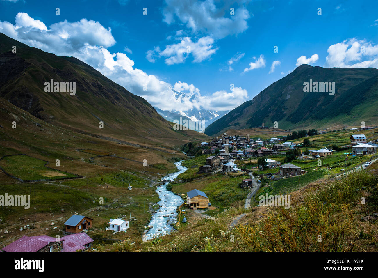 Village Ushguli landscape with massive rocky mountains Bezengi wall ...