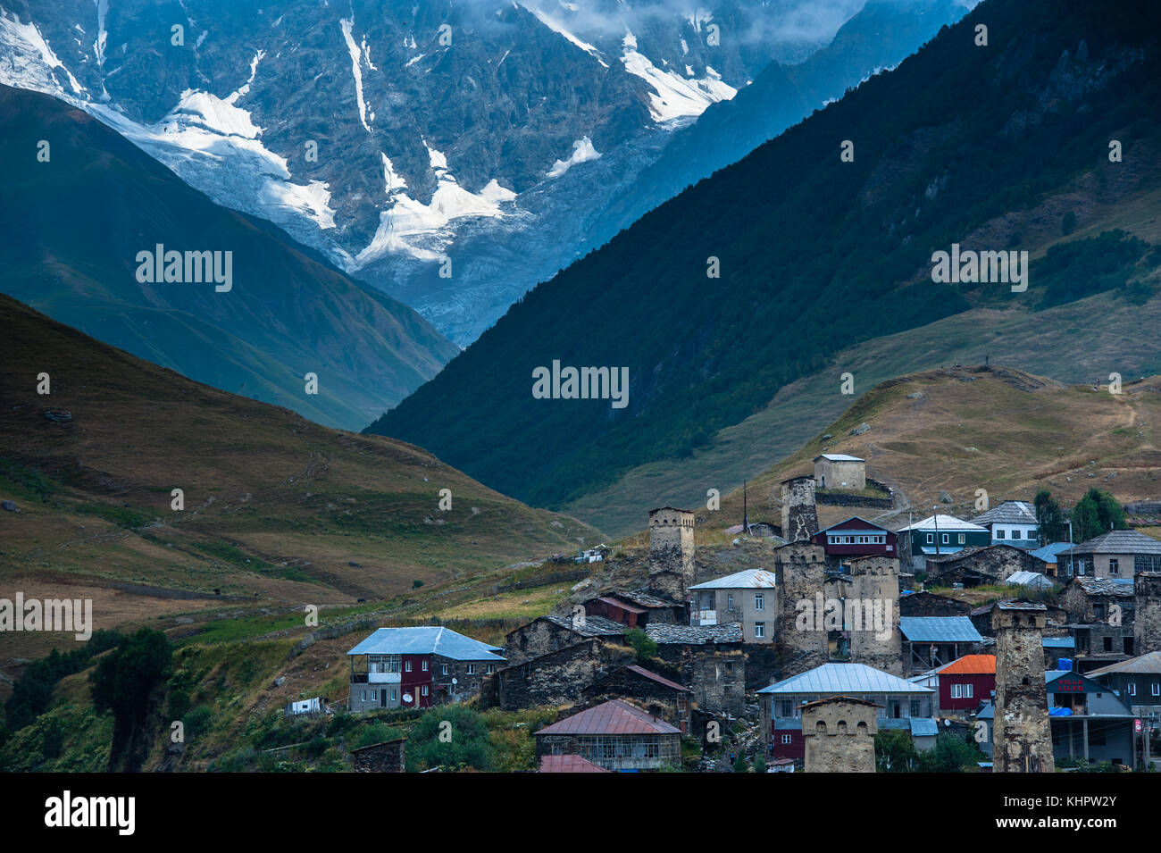 Village Ushguli landscape with massive rocky mountains Bezengi wall ...