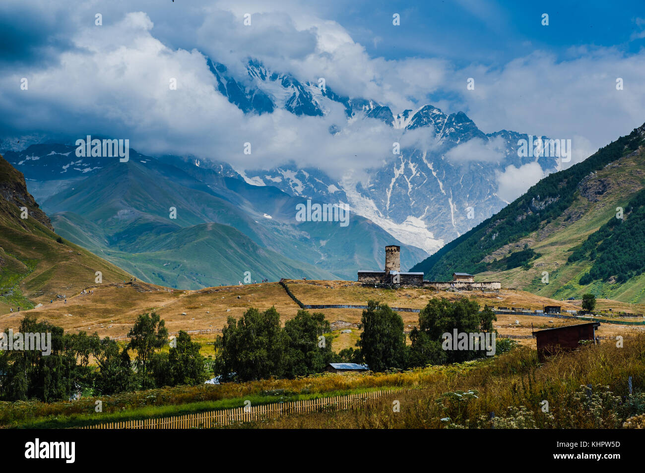 Village Ushguli landscape with massive rocky mountains Bezengi wall ...