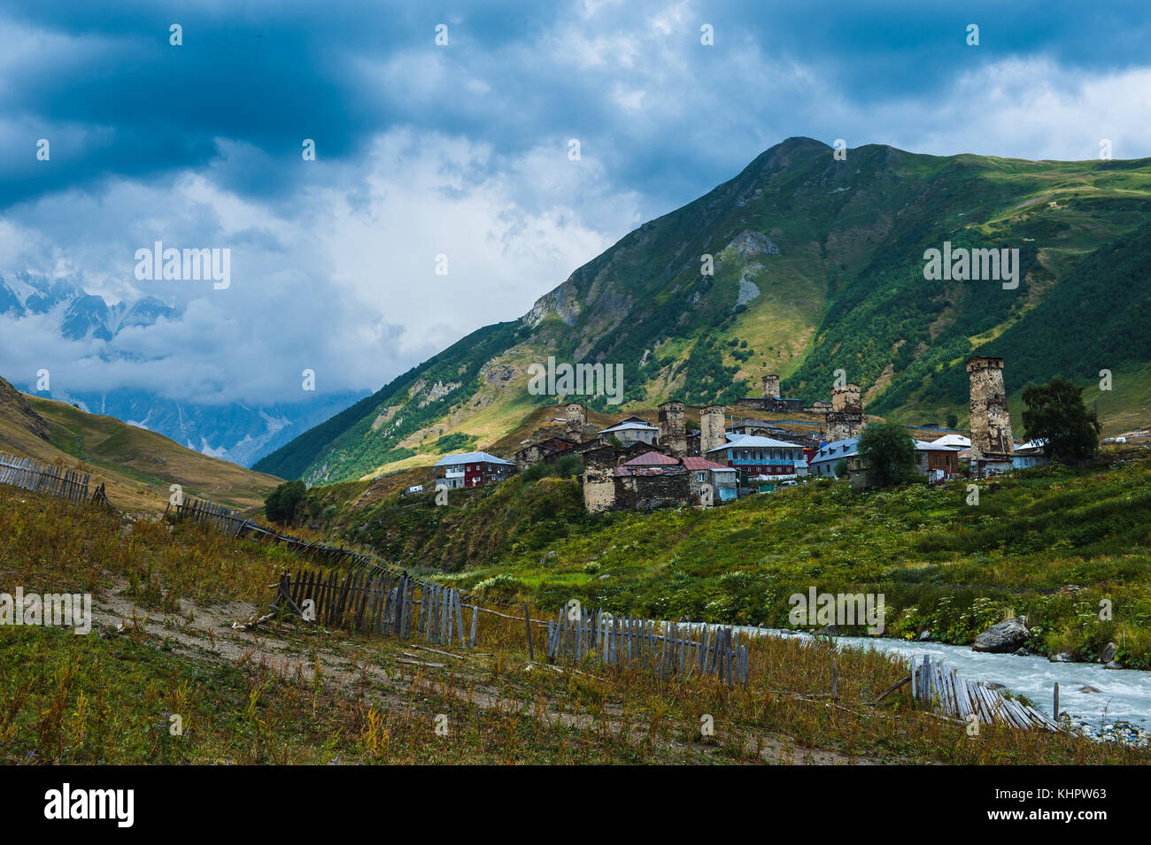 Village Ushguli landscape with massive rocky mountains Bezengi wall ...