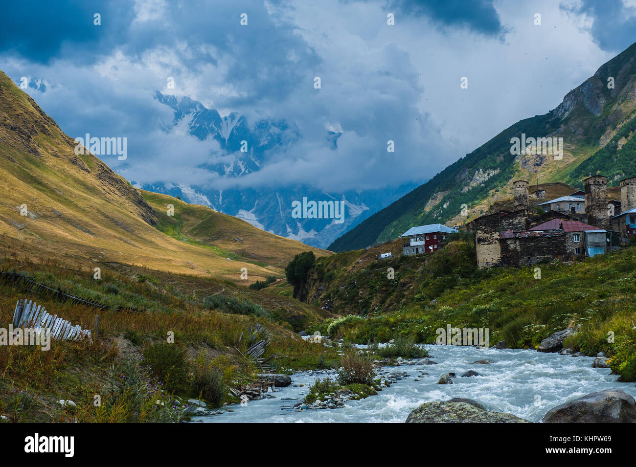 Village Ushguli landscape with massive rocky mountains Bezengi wall ...