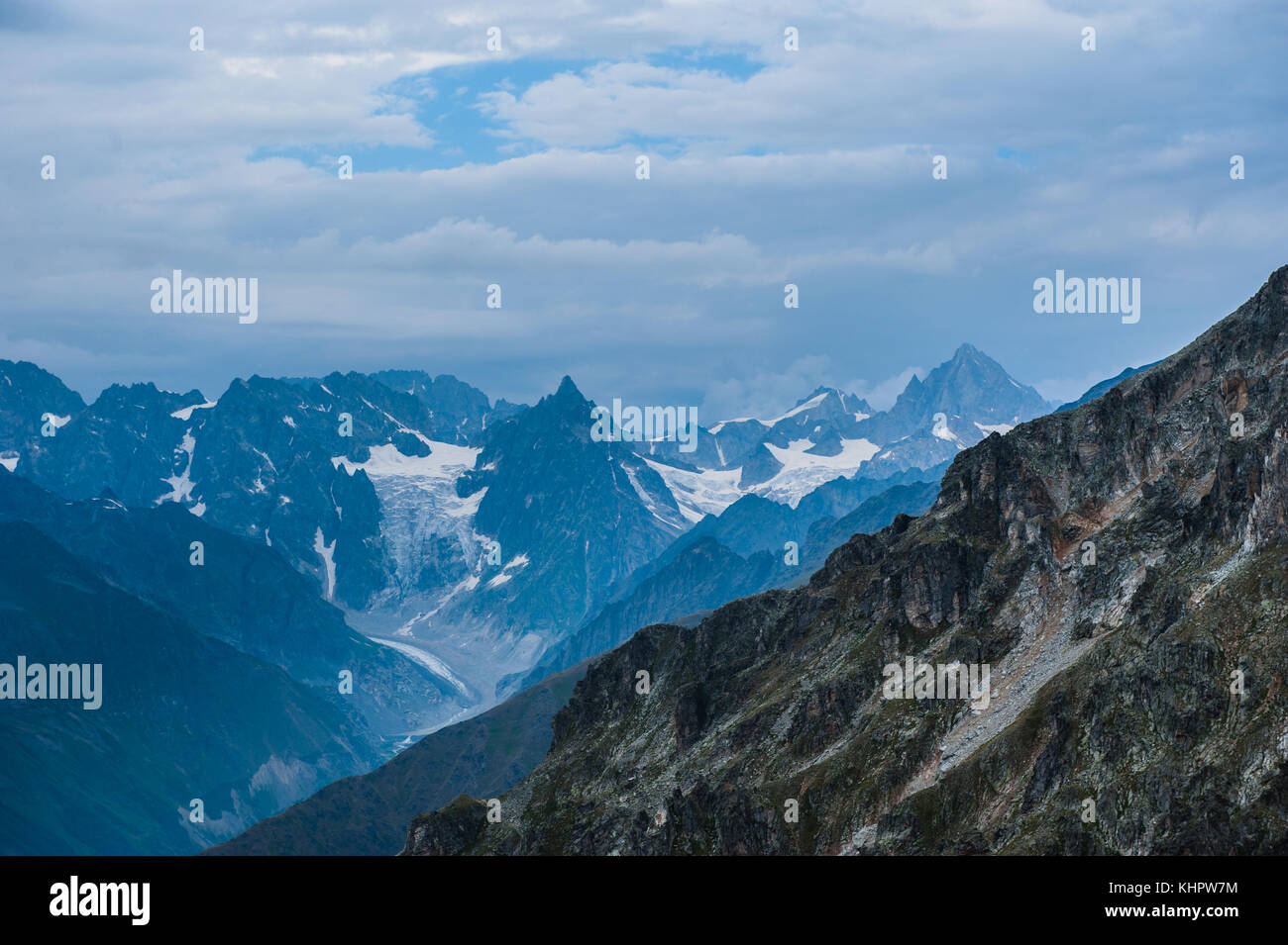 Mountain valley with snow peaks and clouds in Tetnuldi, Mestia, Georgia ...