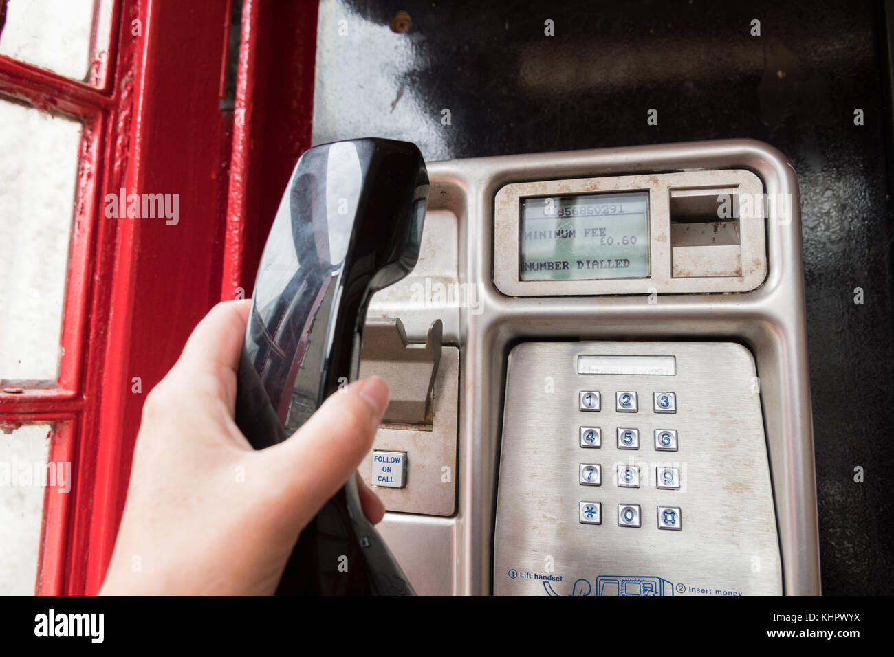 using a BT payphone in red telephone box Stock Photo - Alamy