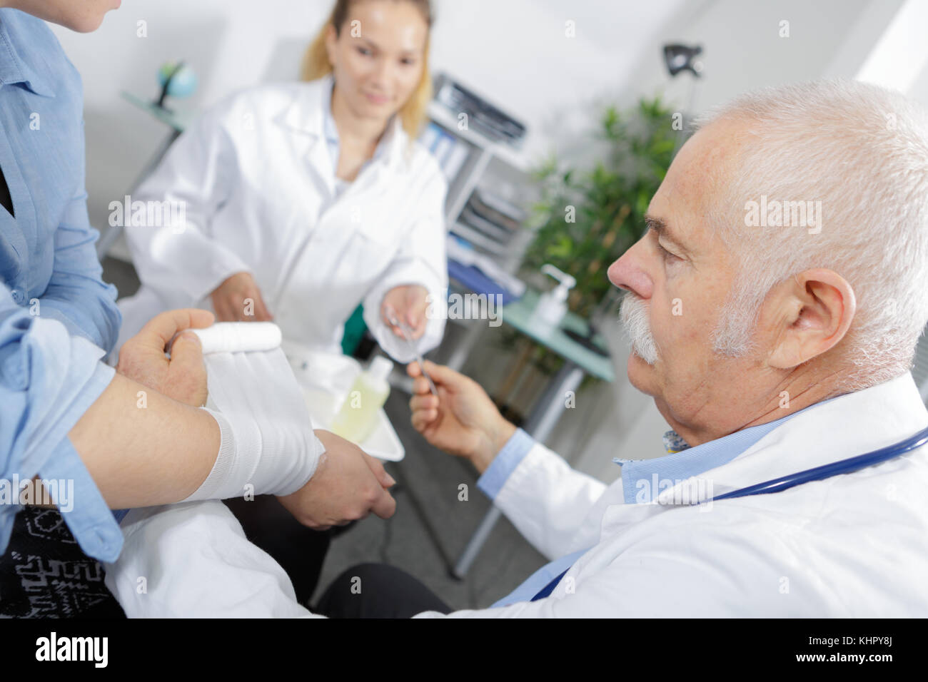 senior doctor bandaging a hand with wrist contusion Stock Photo - Alamy