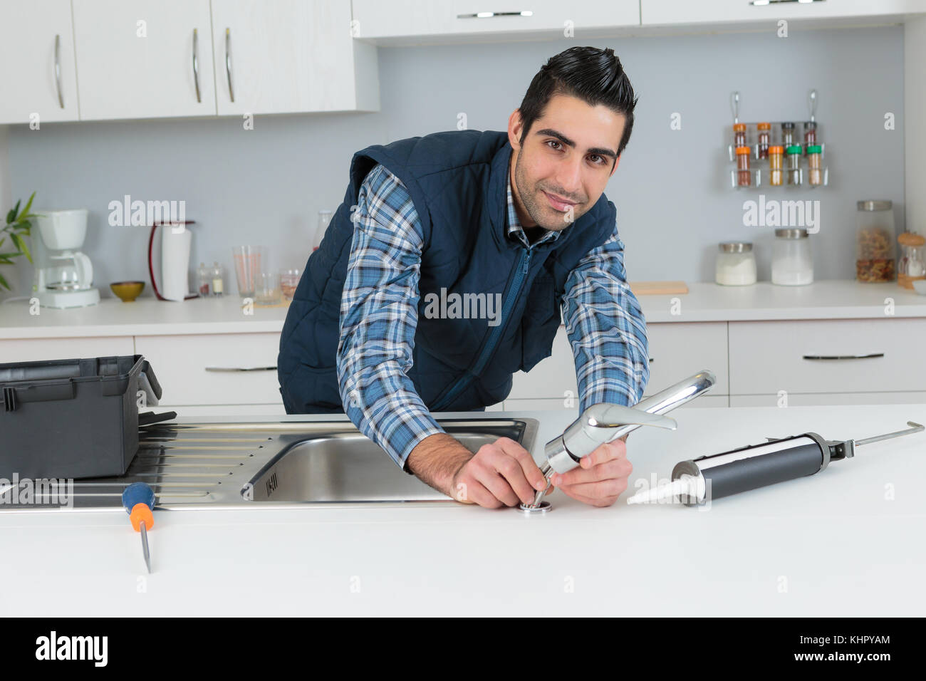 man fixing tap with tool in the kitchen at home Stock Photo - Alamy