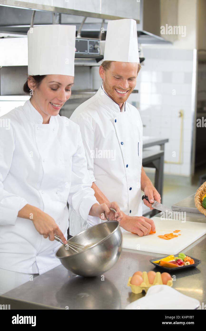 happy chef with beautiful smiling female assistant at kitchen Stock ...