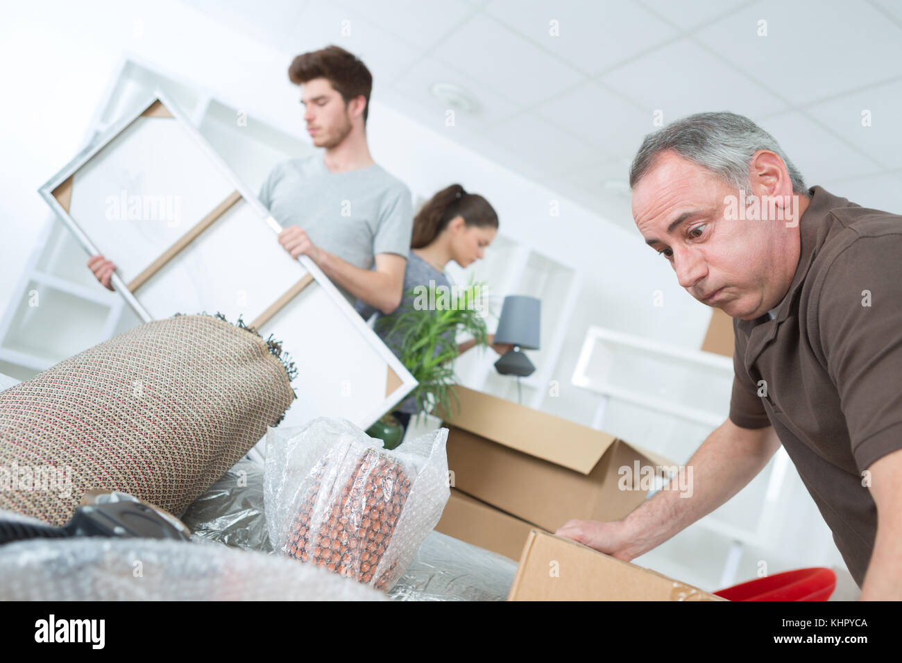 tired dad helping daughter and boyfriend moving houses Stock Photo - Alamy