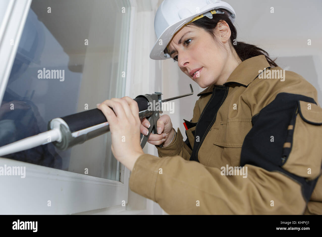 female construction worker installing window in house Stock Photo - Alamy
