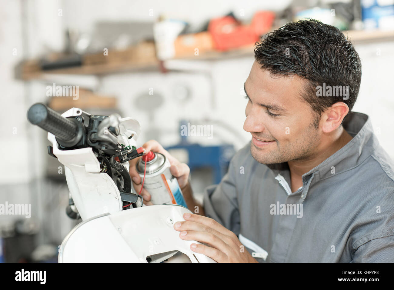 Mechanic working on a scooter Stock Photo - Alamy
