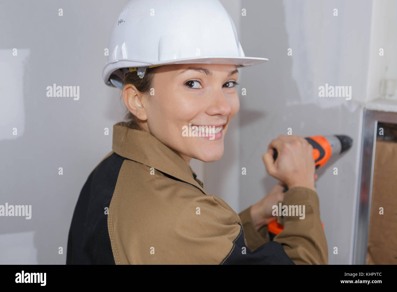 happy female builder drilling Stock Photo - Alamy