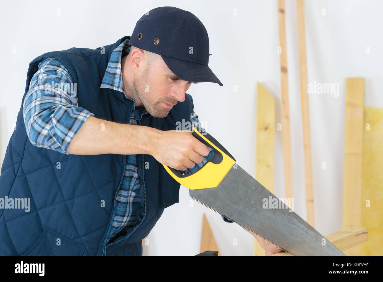 man sawing wood handsaw on a carpentry table Stock Photo - Alamy