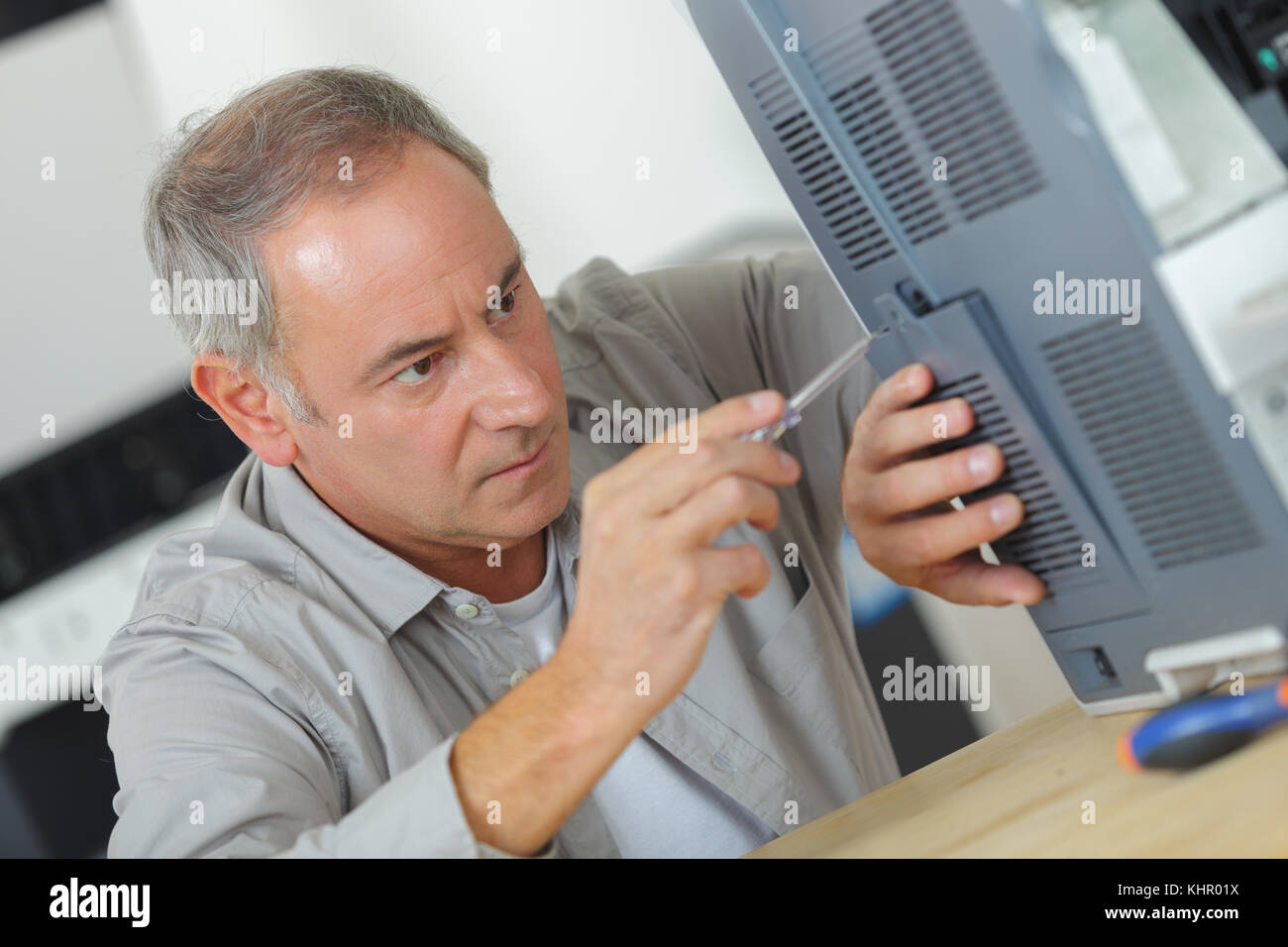 male technician checking machine with screwdriver Stock Photo - Alamy
