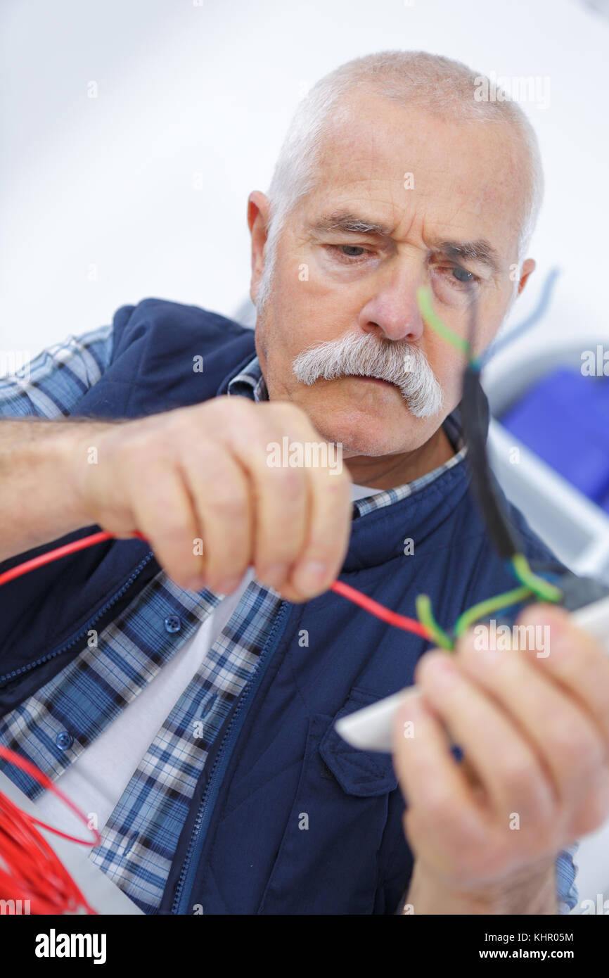 senior worker plugging socket type to electrical outlet Stock Photo - Alamy
