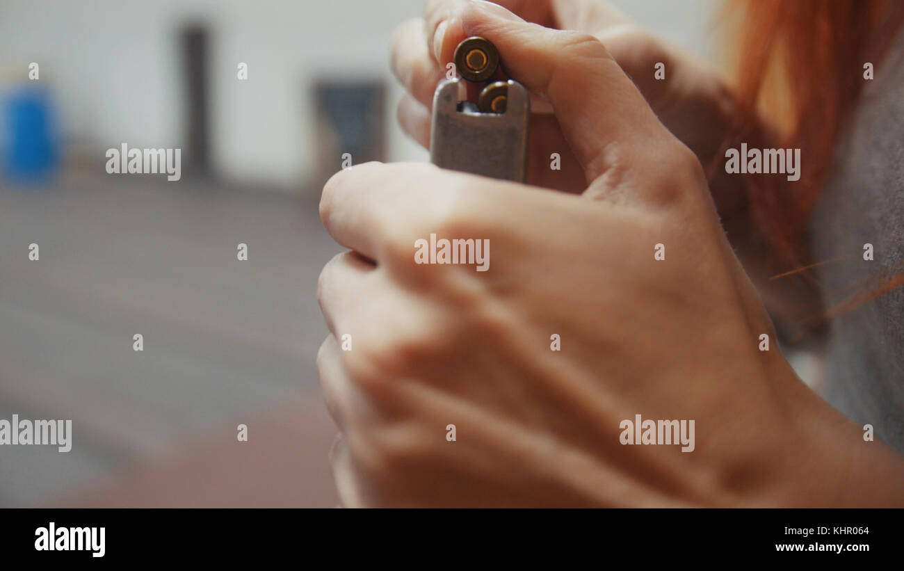 Female's hands in shooting gallery loads the gun with bullets Stock ...