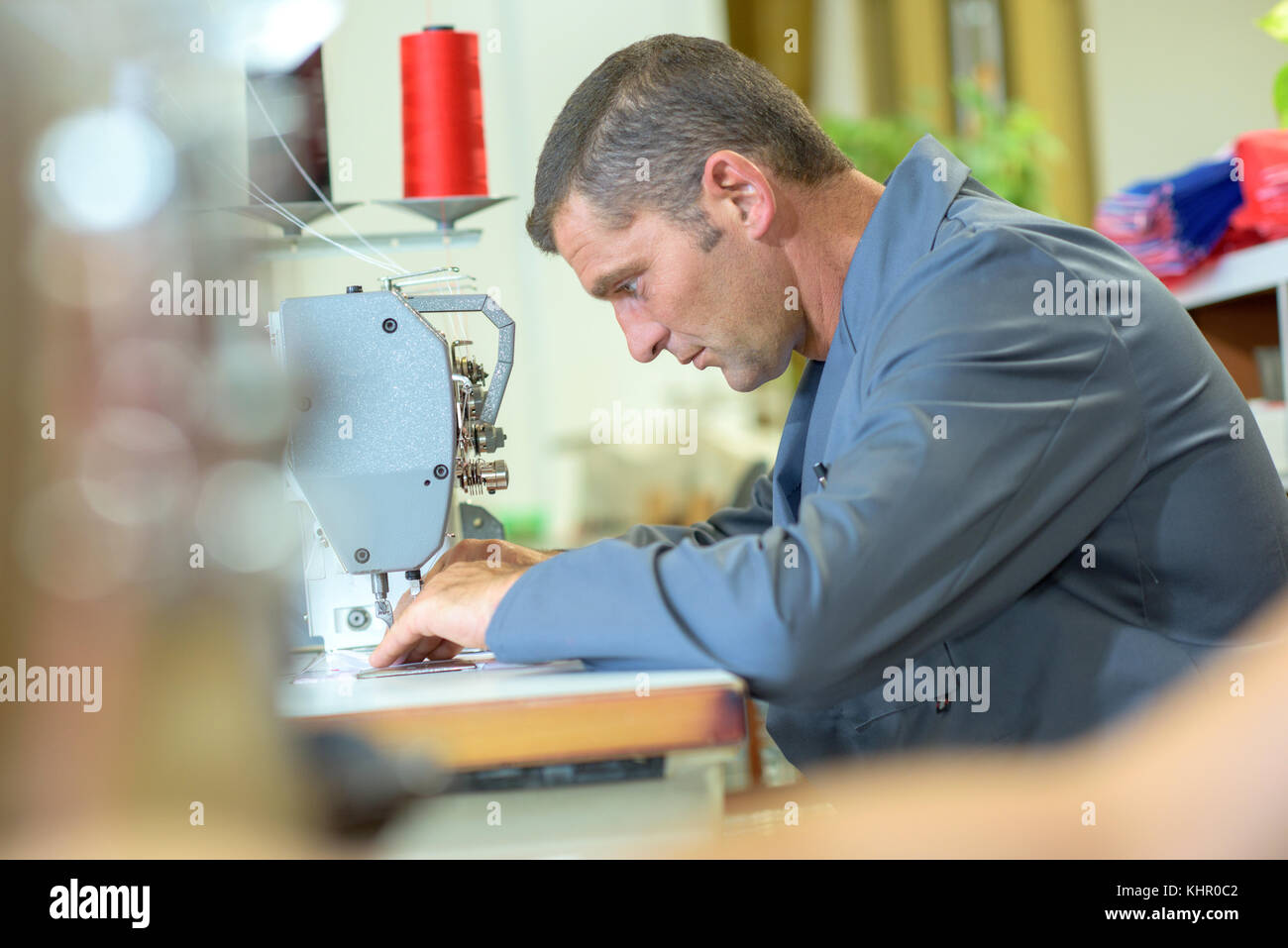 Middle aged man using sewing machine Stock Photo - Alamy