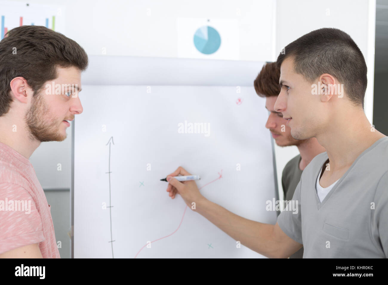 3 students writing on the board Stock Photo - Alamy