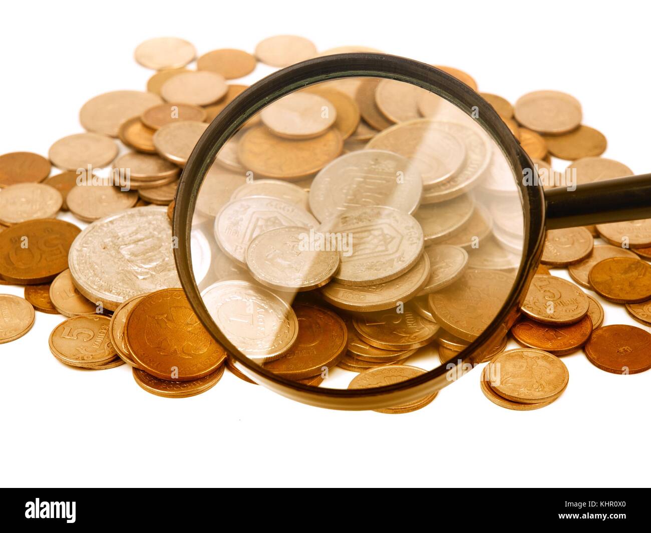 Loupe and coins on white background Stock Photo - Alamy