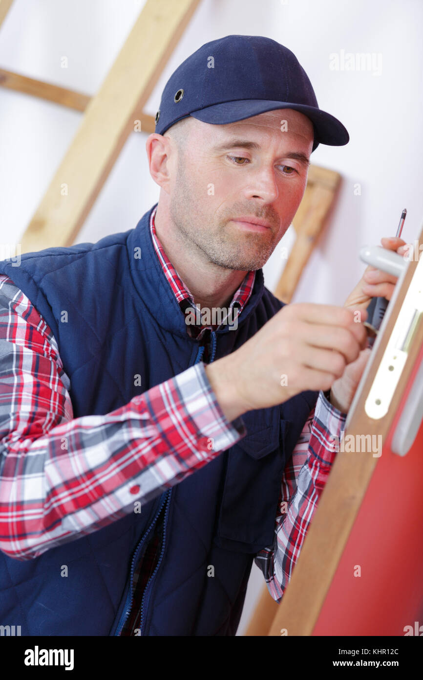man fixing the door with screwdriver Stock Photo - Alamy