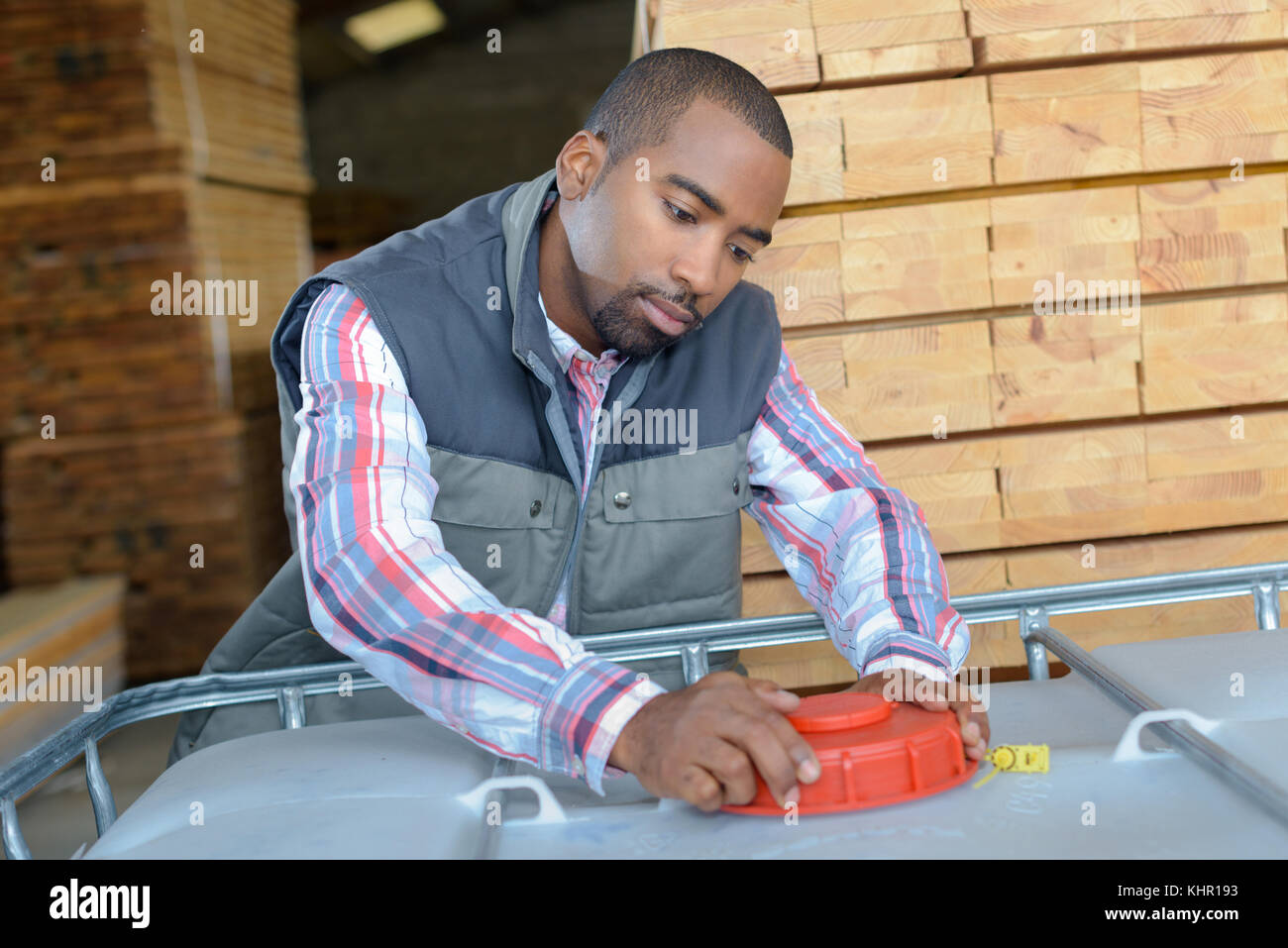 man turning top of large container Stock Photo - Alamy