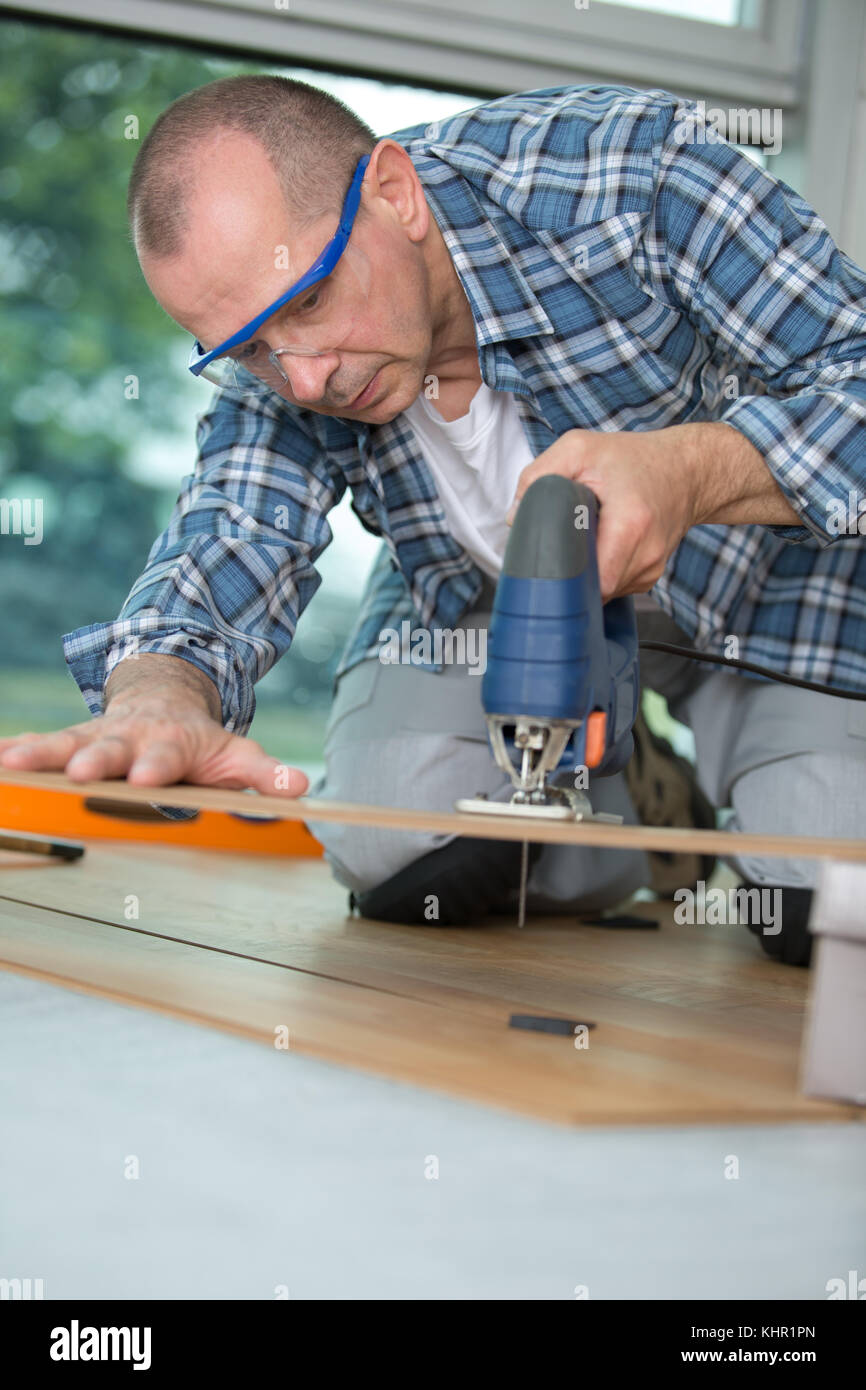 man using saw to cut wood Stock Photo - Alamy