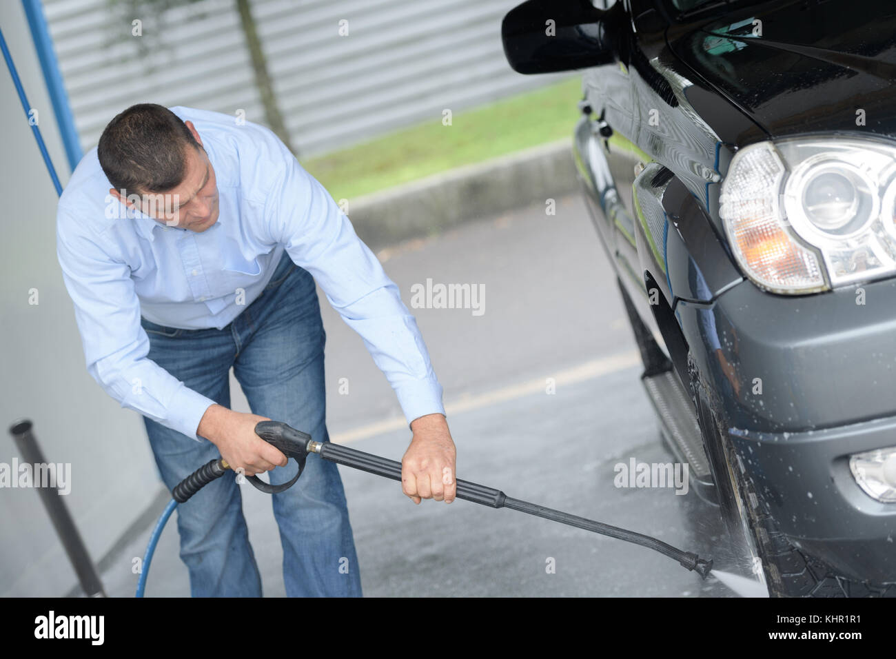 young man cleaning his car with a jet sprayer Stock Photo - Alamy