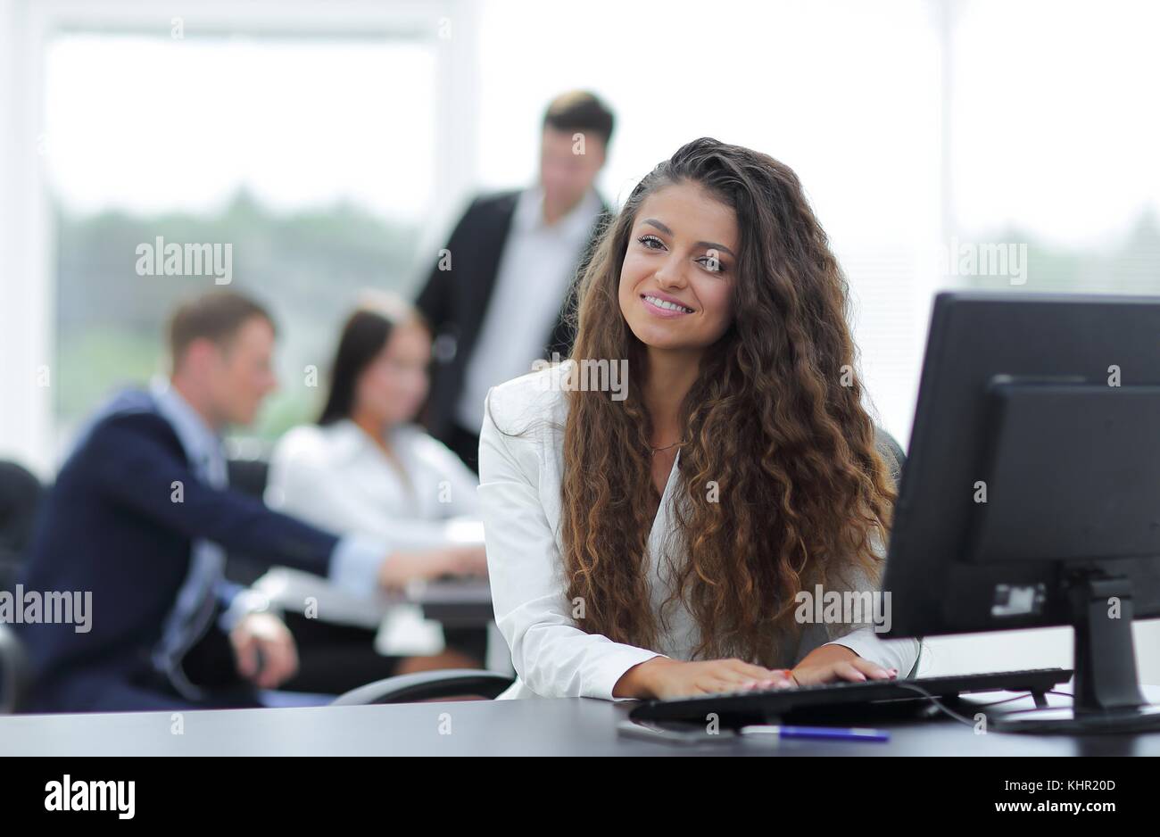Manager woman sitting behind a Desk Stock Photo - Alamy