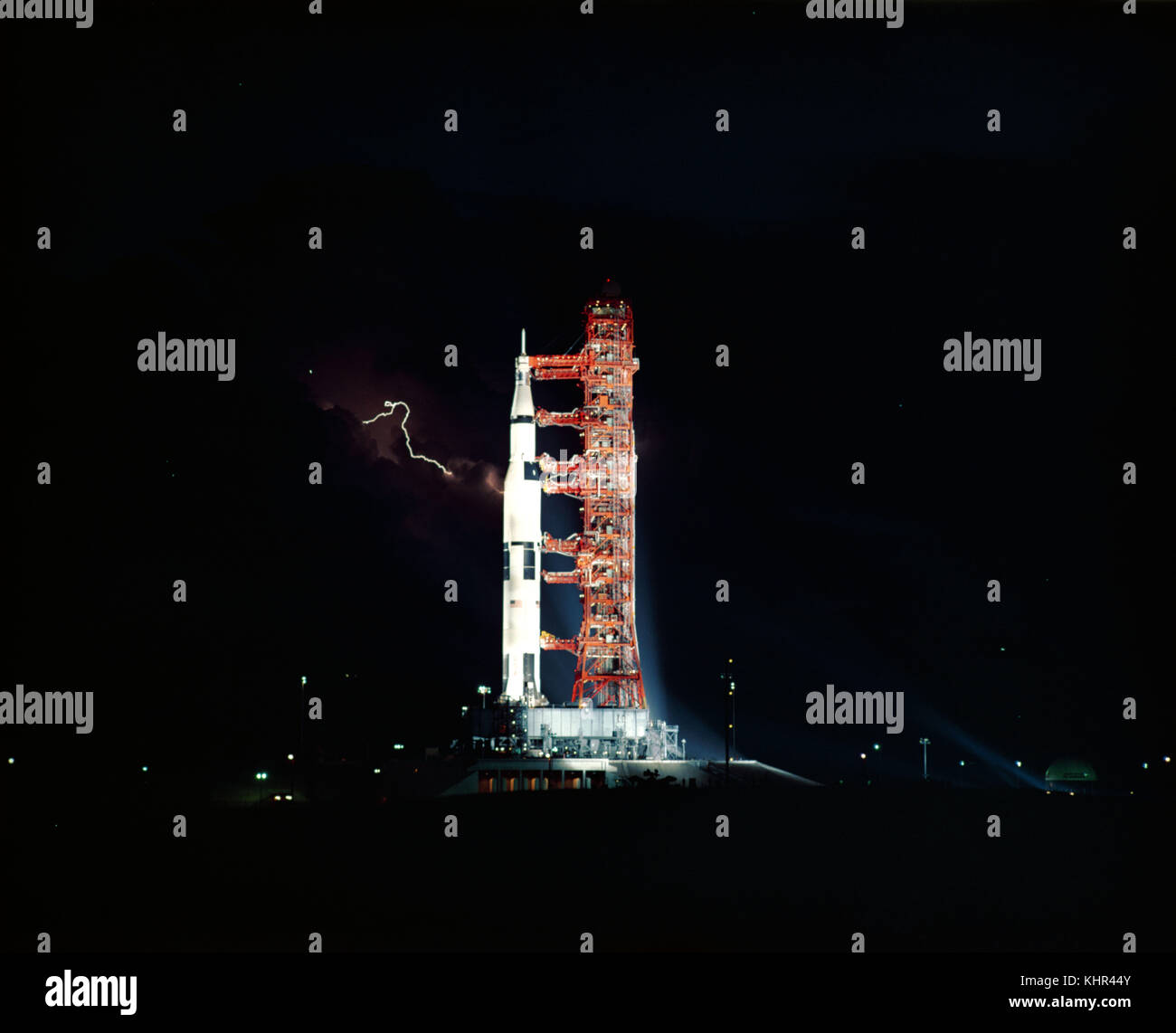 Lightning strikes in the night sky around the NASA Saturn V spacecraft prior to the Apollo 15 ...