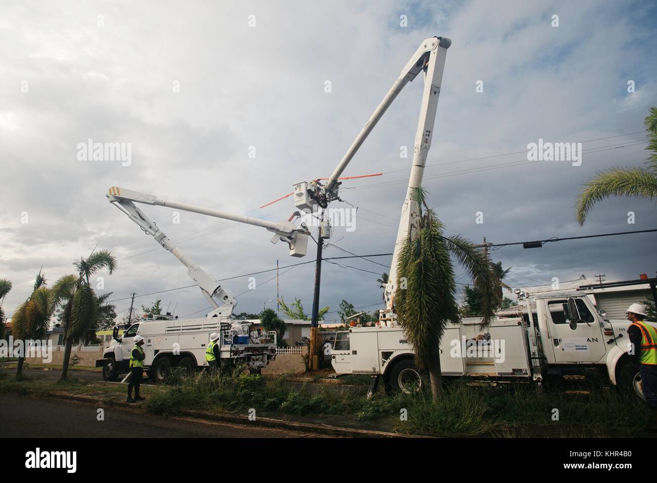 Utility workers repair a damaged electrical transformer to restore ...