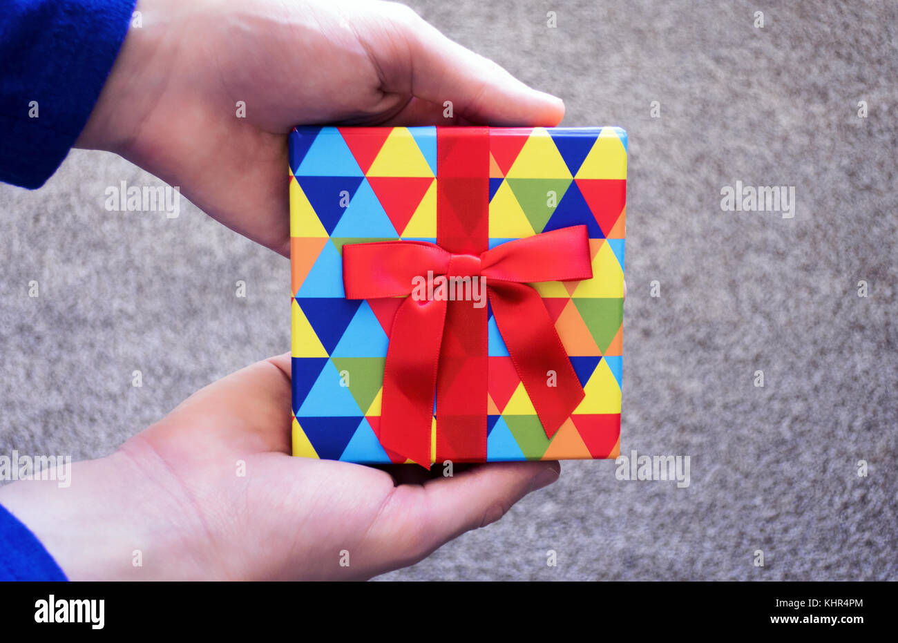 A man holding a small, colorful gift card box out Stock Photo - Alamy