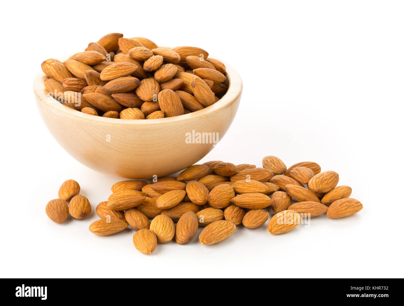 Heap of shelled almond kernels in wooden bowl over white background ...