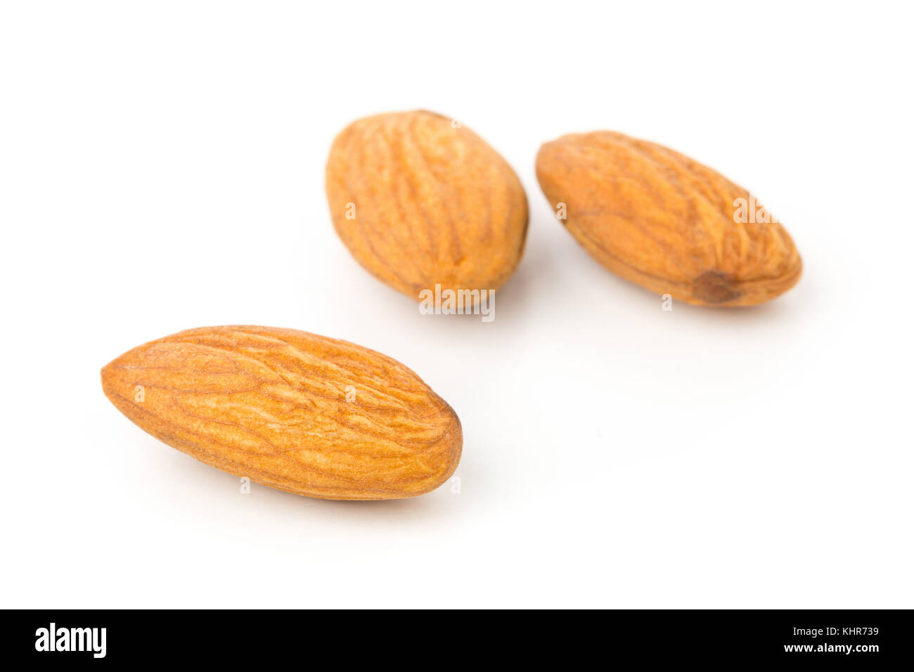 Macro of shelled almond kernels with selective focus over white ...