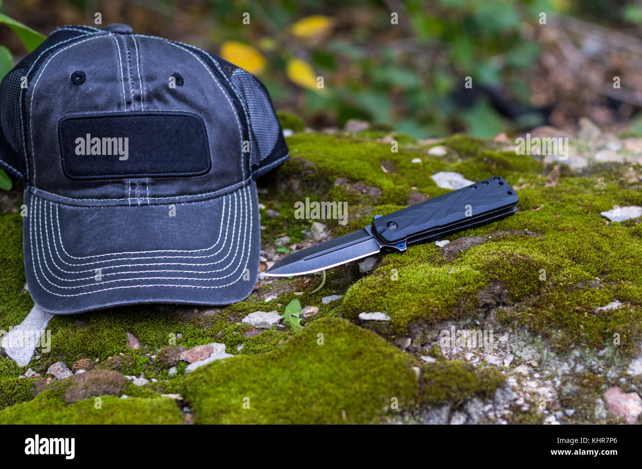 Black knife and black cap. Folding knife and baseball cap. Photo on the ...