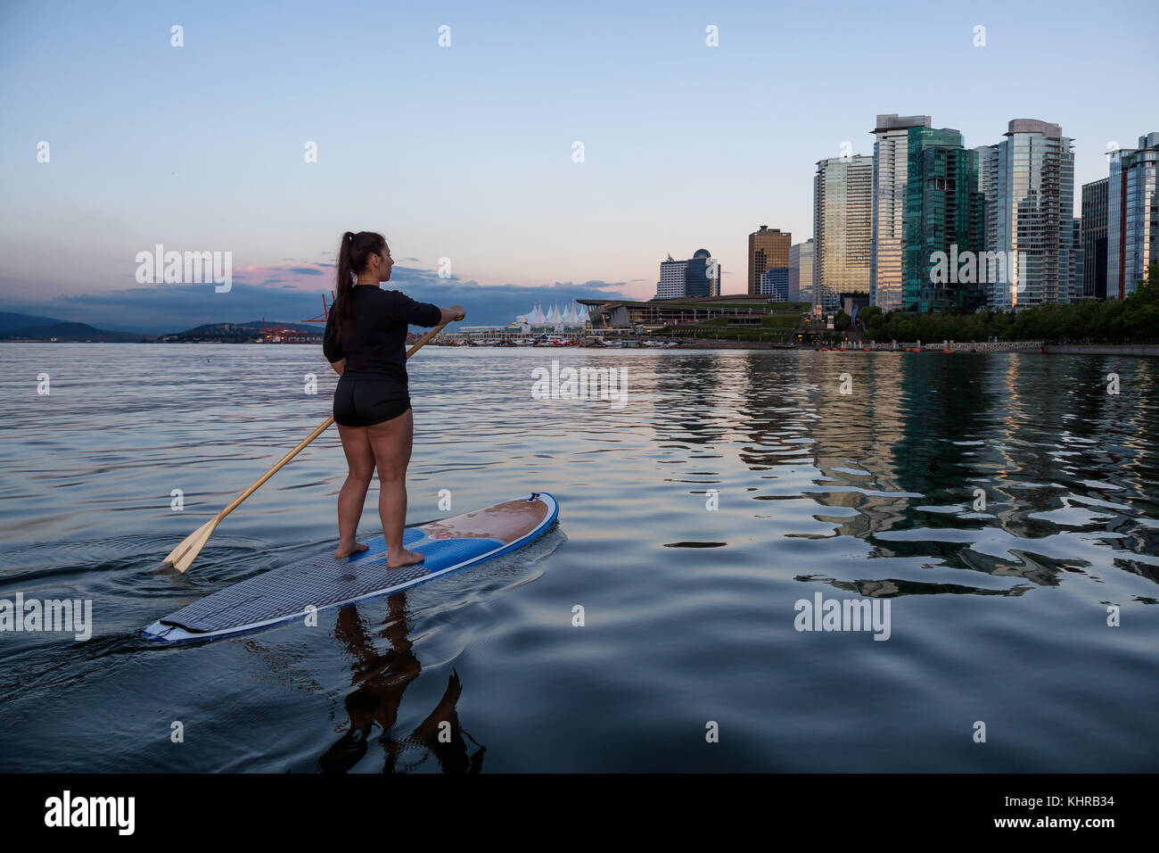 Girl on a standup paddle board in Coal Harbour, Downtown Vancouver ...