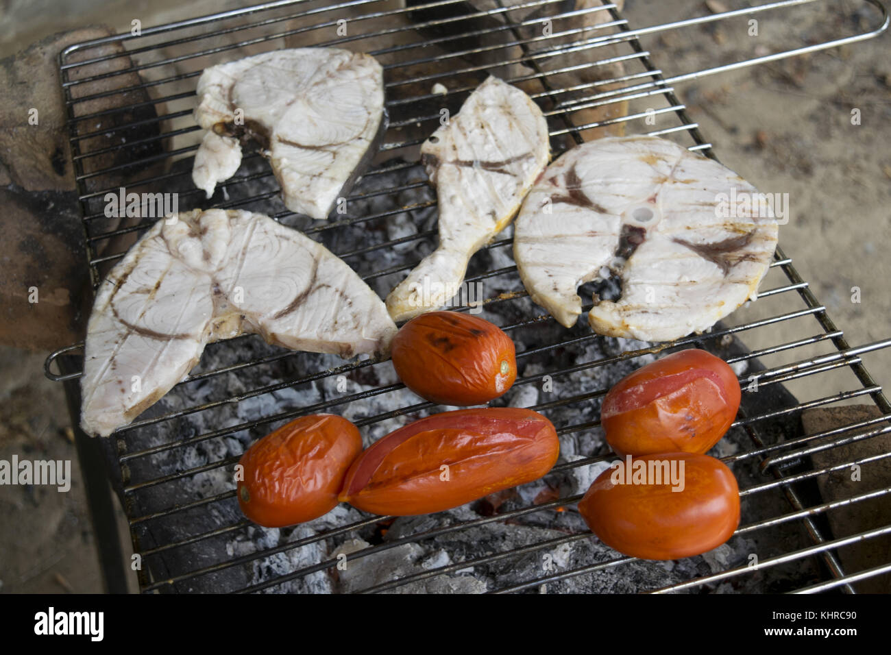 swordfish fillets and fresh tomatoes cooked on the ember Stock Photo ...