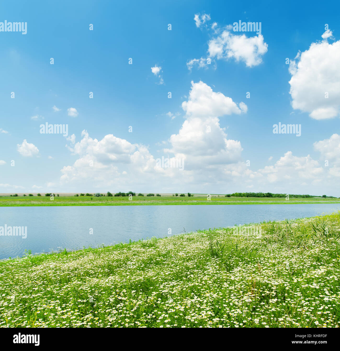 river in green grass and white clouds over it Stock Photo - Alamy