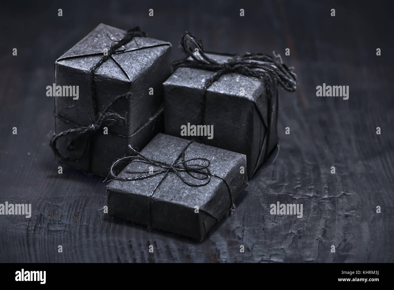 three black paper boxes on black wooden background, close up, concept ...