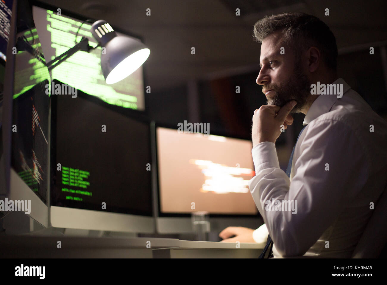 Profile view of pensive bearded coder wrapped up in work while sitting ...