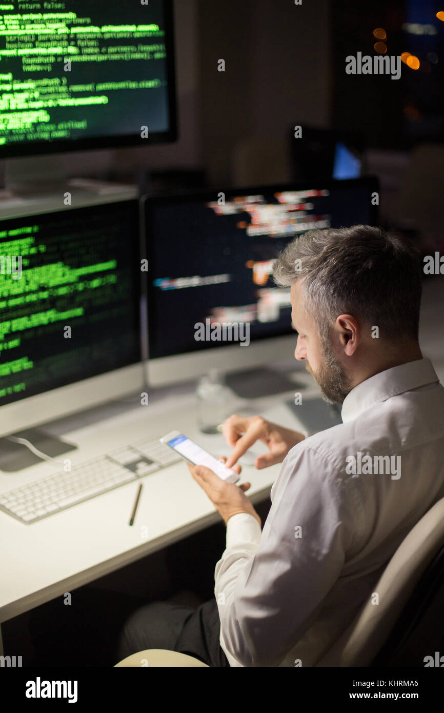 Confident middle-aged software developer texting with friend on ...