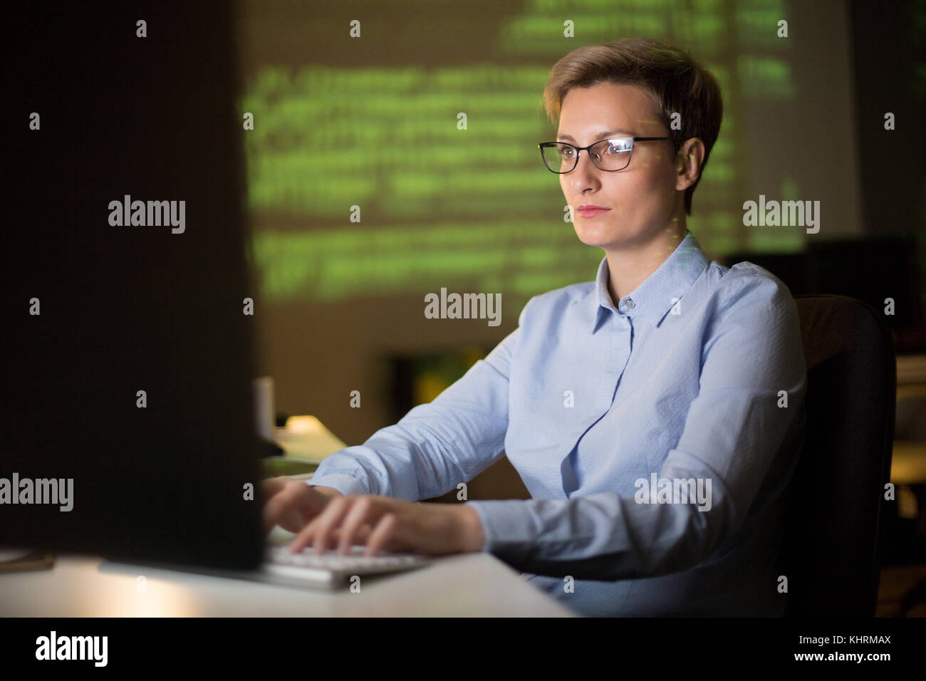 Pretty middle-aged entrepreneur sitting in front of computer and making ...