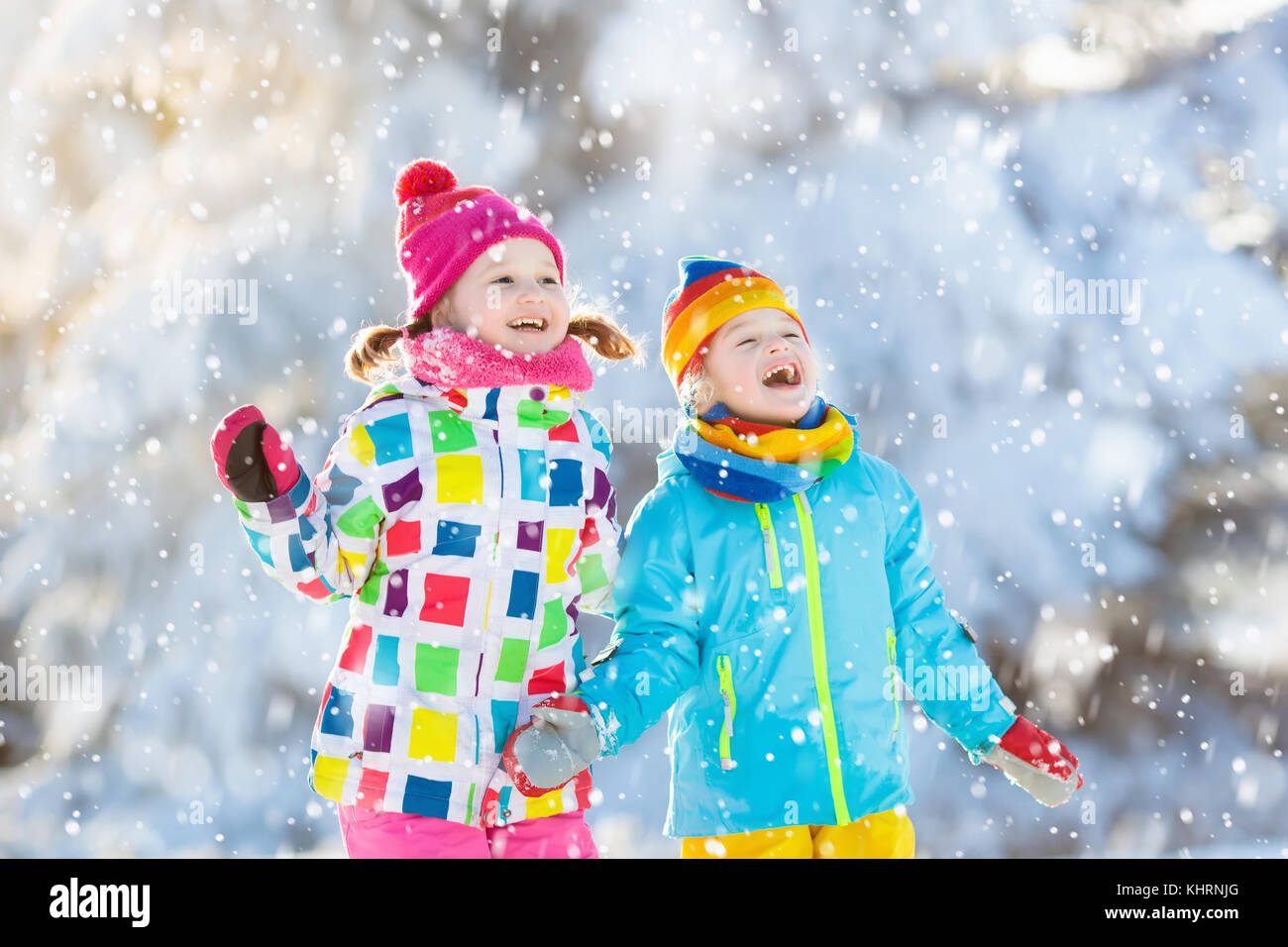 Kids playing in snow. Children play outdoors on snowy winter day. Boy ...