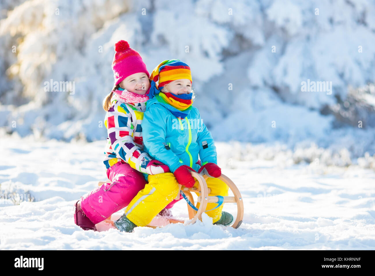 Little girl and boy enjoying sleigh ride. Child sledding. Toddler kid ...