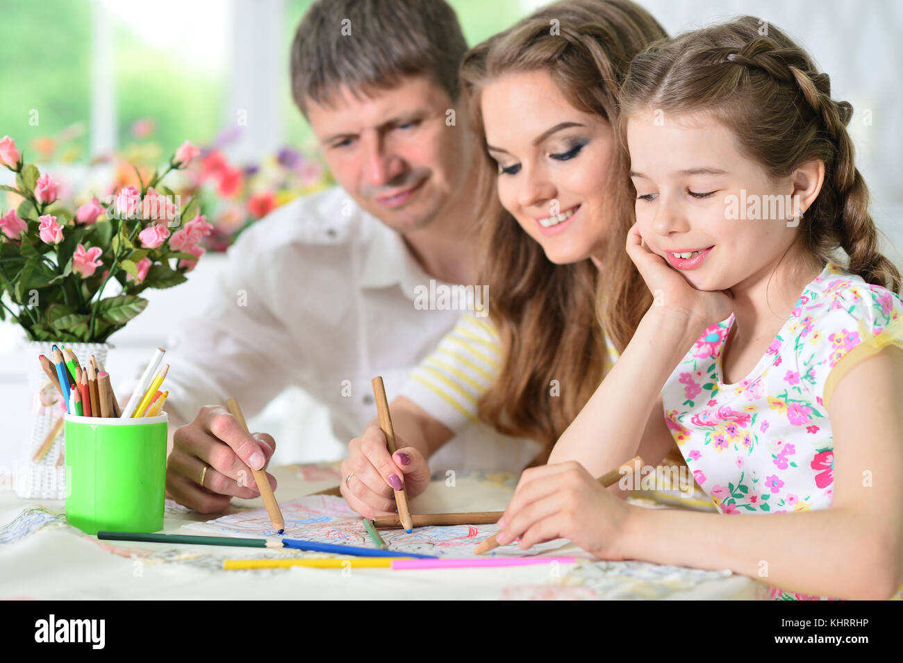 Portrait of happy parents drawing with their daughter together Stock ...