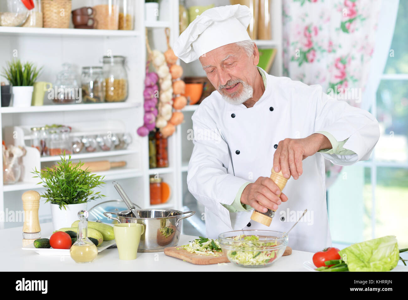Senior male chef preparing dinner in kitchen Stock Photo - Alamy