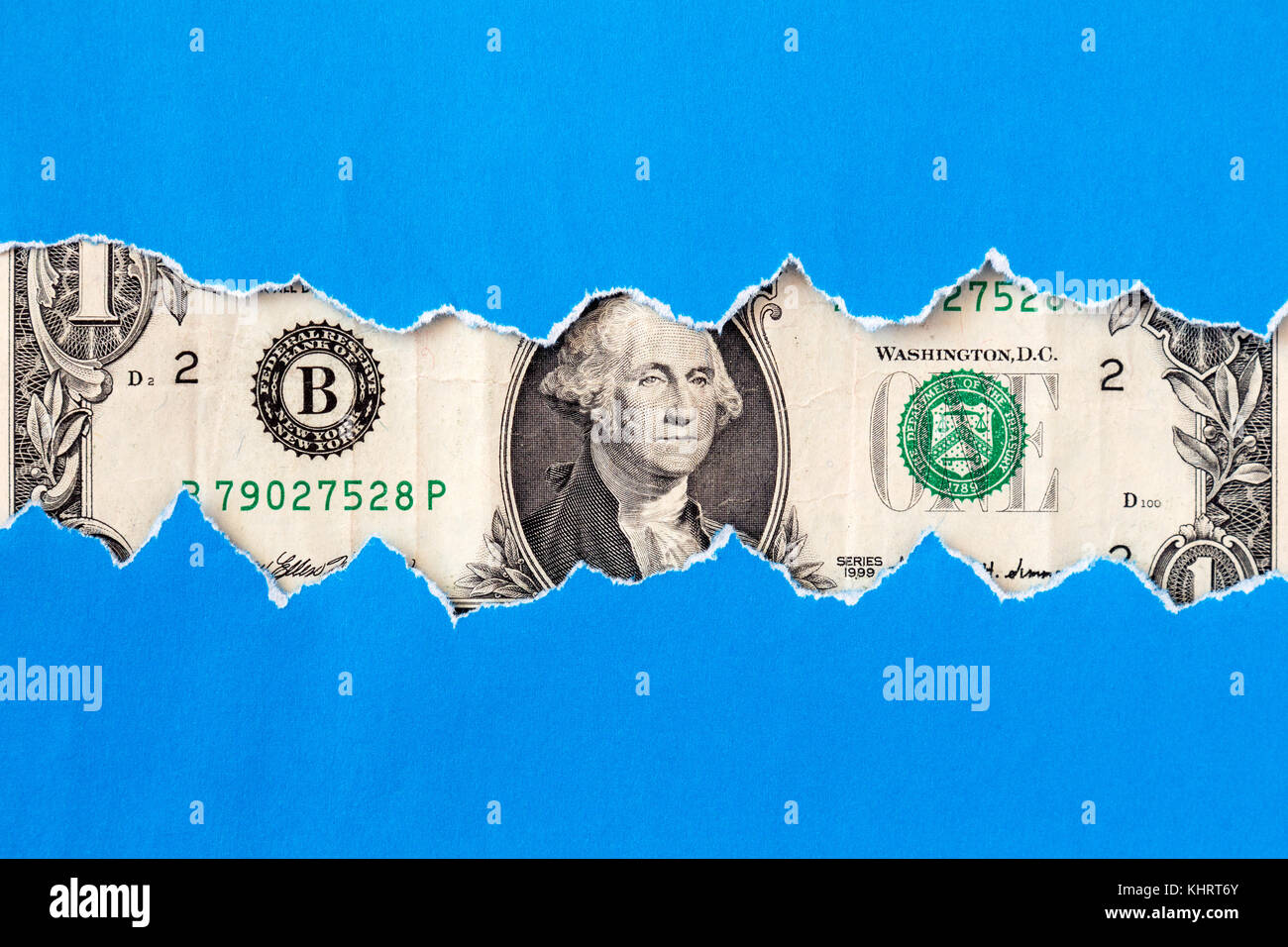One dollar macro through torn blue paper Stock Photo - Alamy