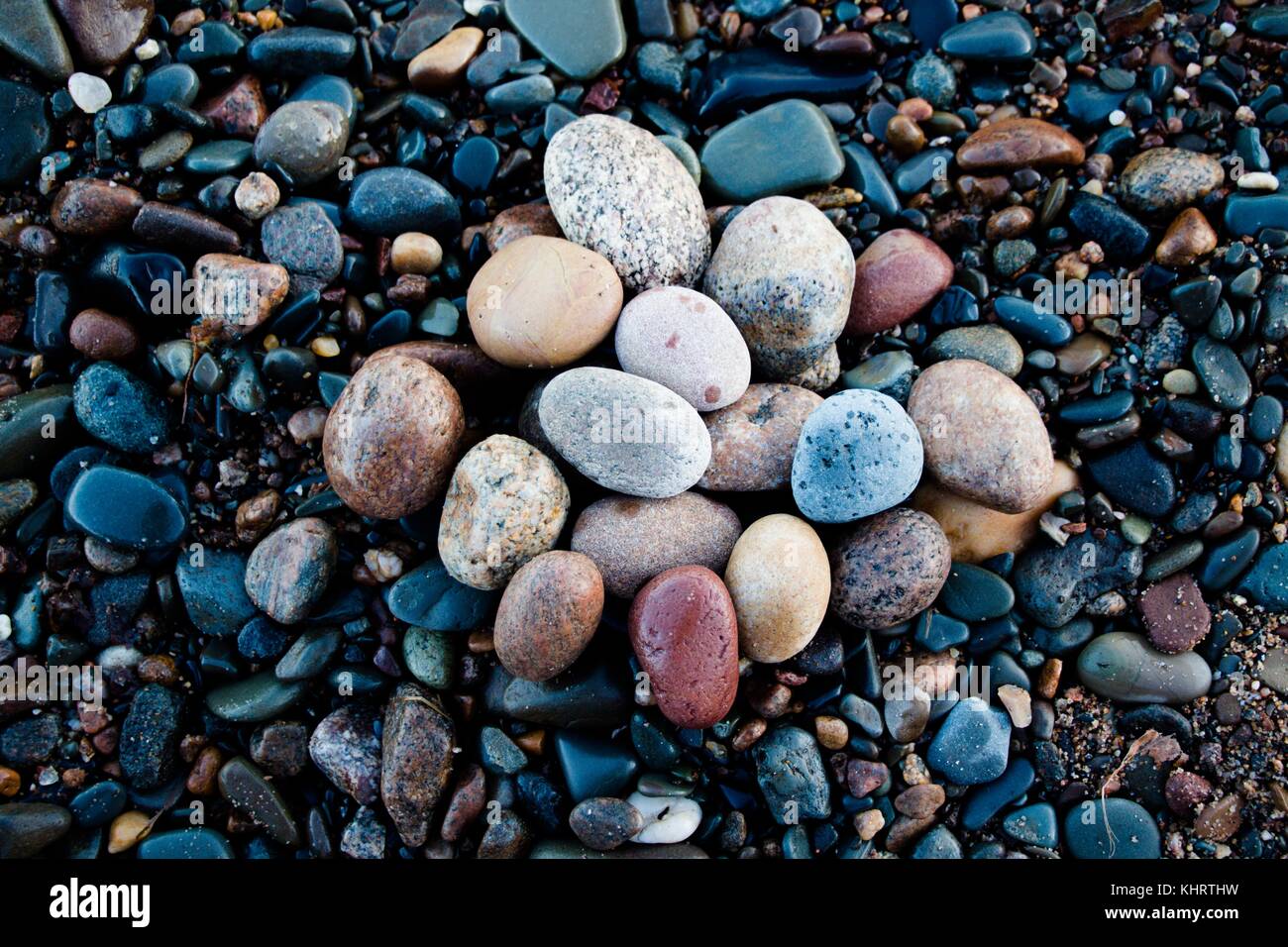 Stones of different shades and different oval shapes lie on the stony ...