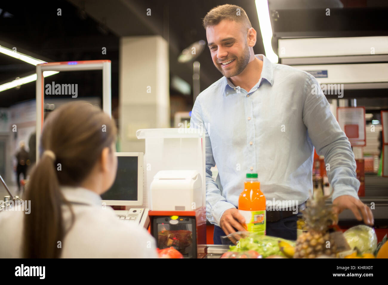 Portrait of handsome young man buying food in supermarket smiling ...