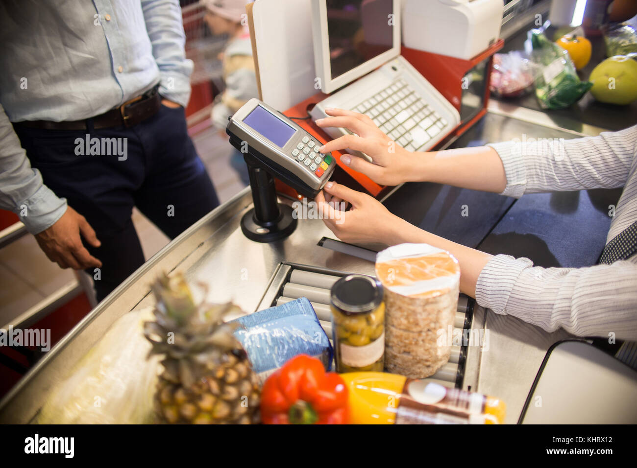 High angle closeup of cashier entering price to paying terminal at cash ...