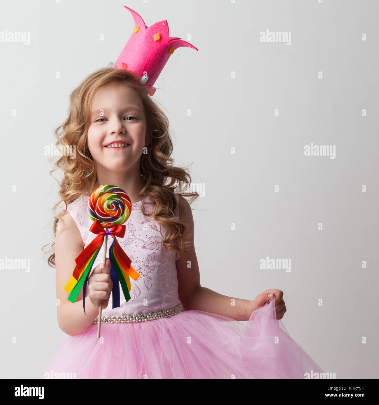 Beautiful little candy princess girl in crown holding big lollipop and ...