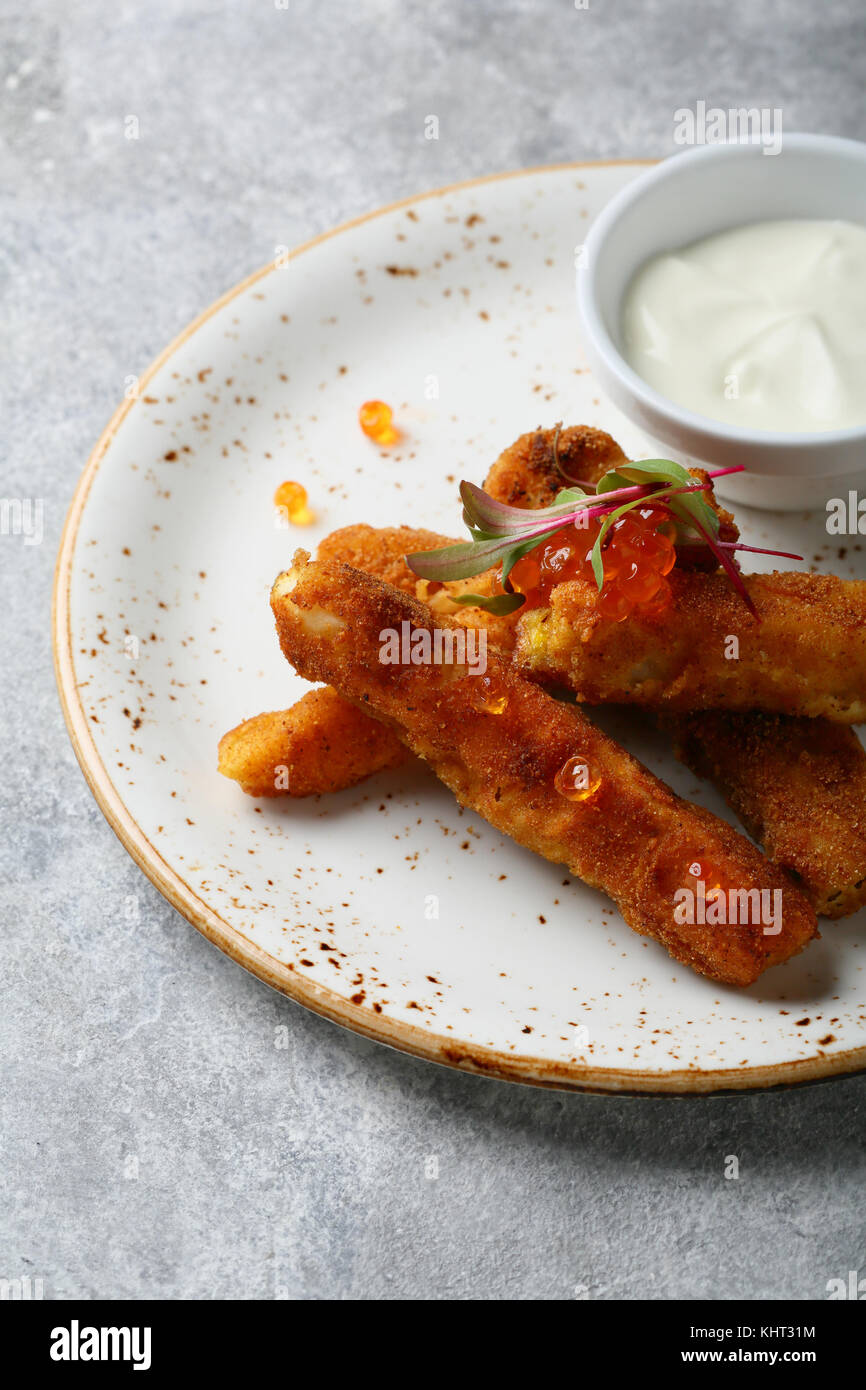 fish fingers with white sauce, food on plate Stock Photo - Alamy
