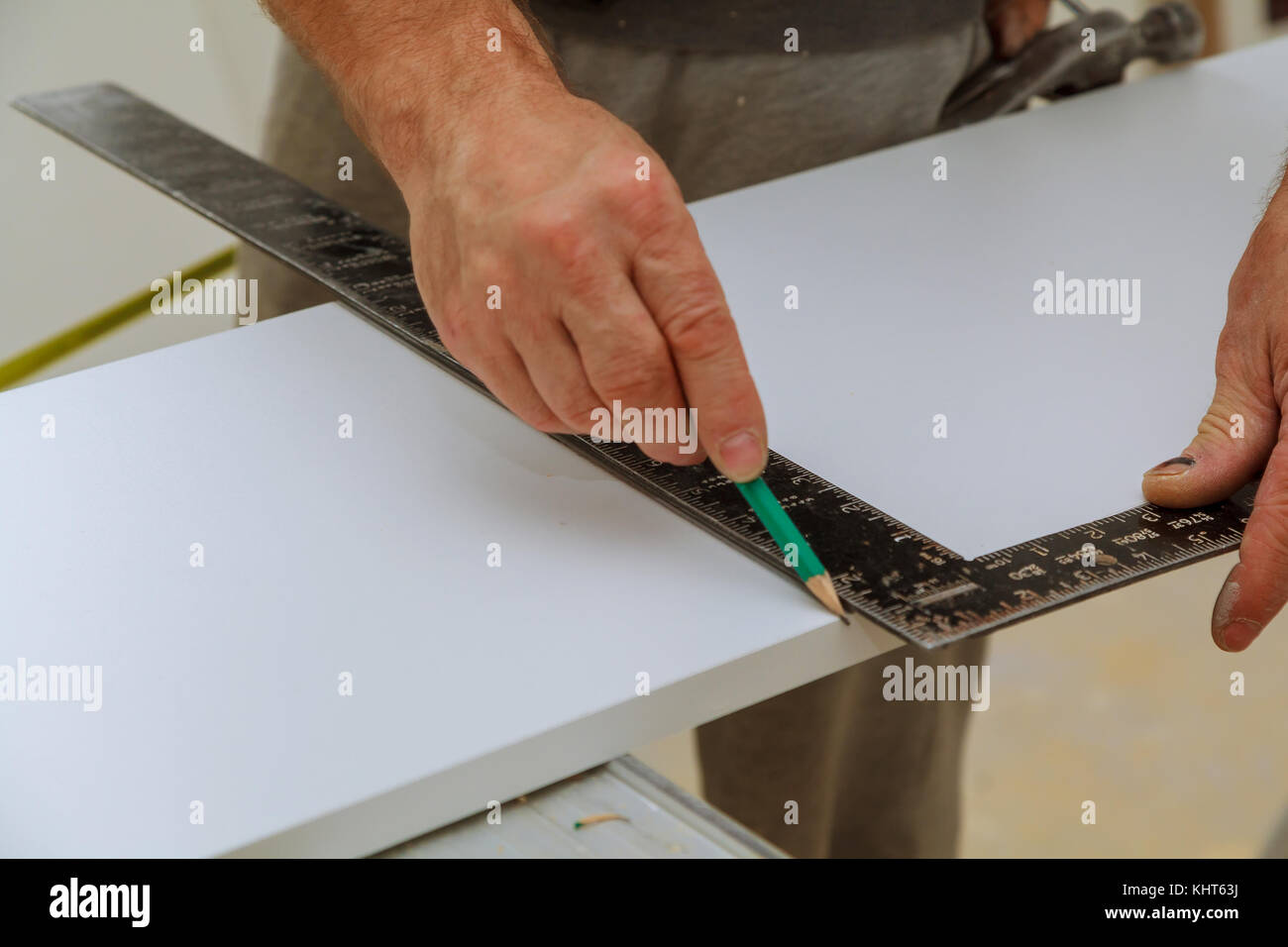 Hand of a carpenter measures the distance using a builder's square and ...